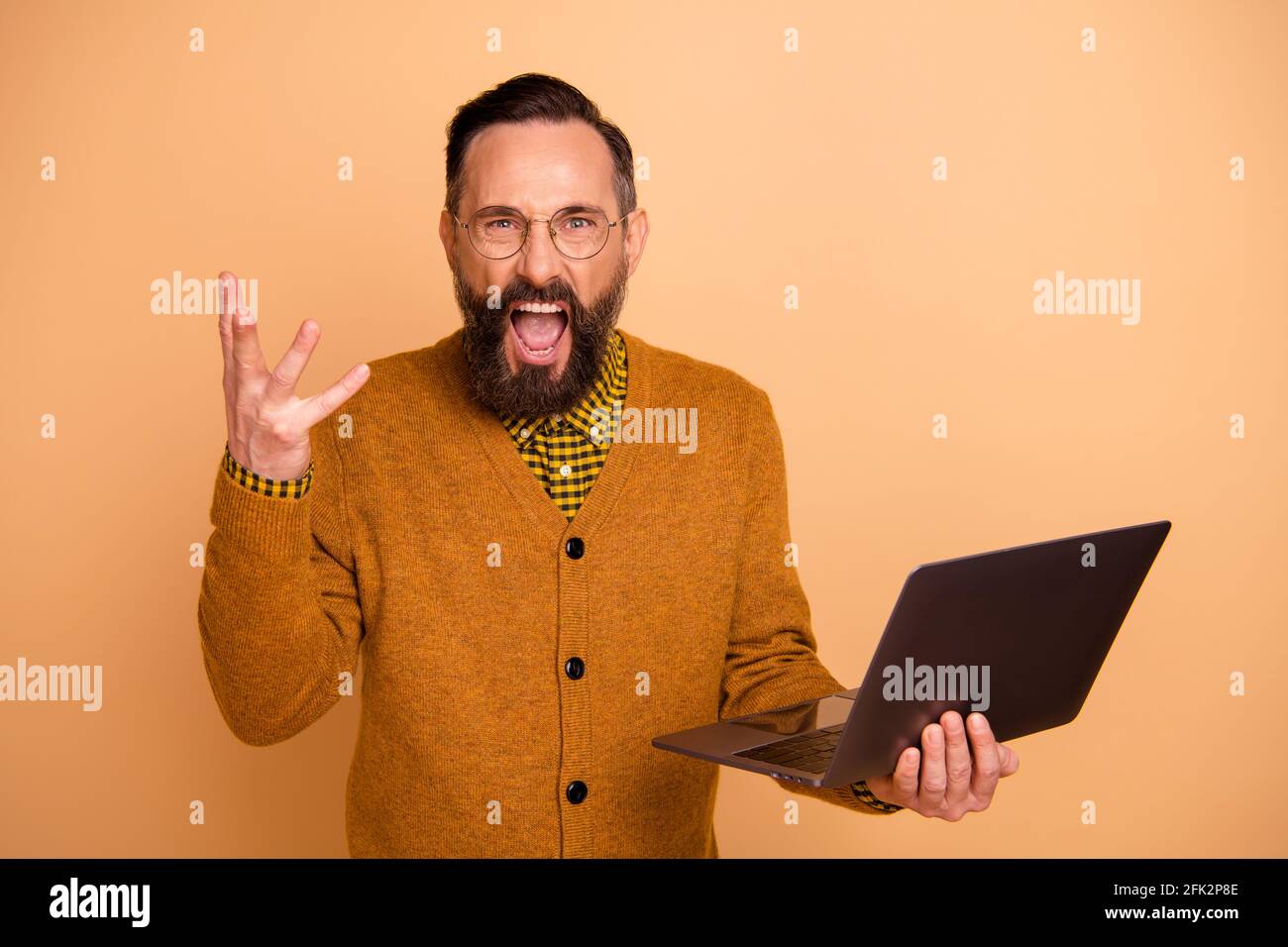 Photo of furious angry mature man hold laptop scream wear sweater ...