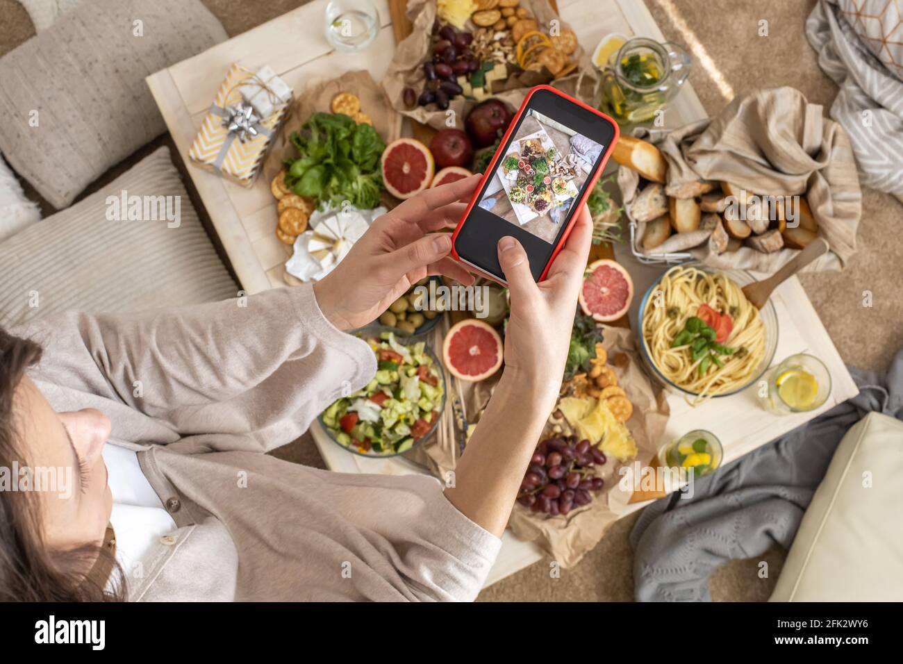 Top view woman photographing dinner table with serving tasty food and ...