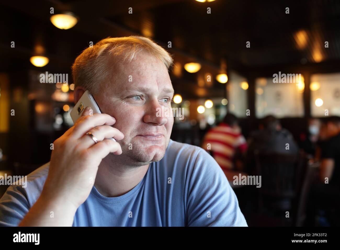 Man is calling from a cafe in the evening Stock Photo - Alamy
