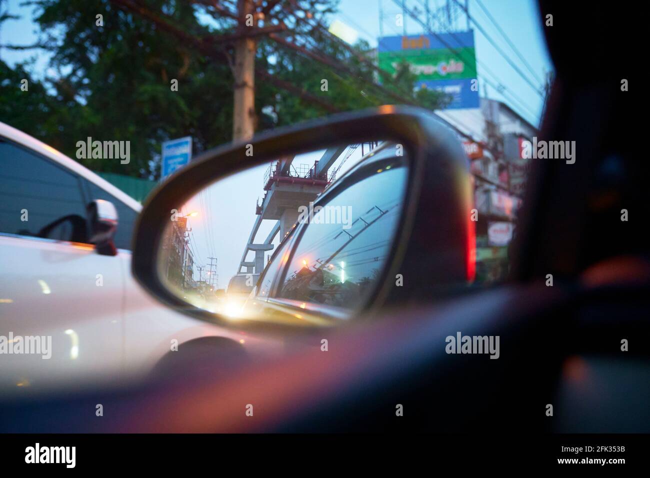 A car wing mirror with the glow of headlights and reflections of ...