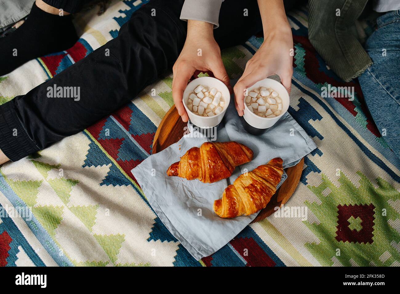 Hands holding mugs with coffee and marshmallows. Couple having a ...