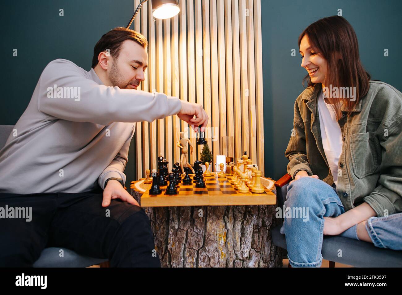Smiling middle aged couple playing a game of chess at home, having fun ...