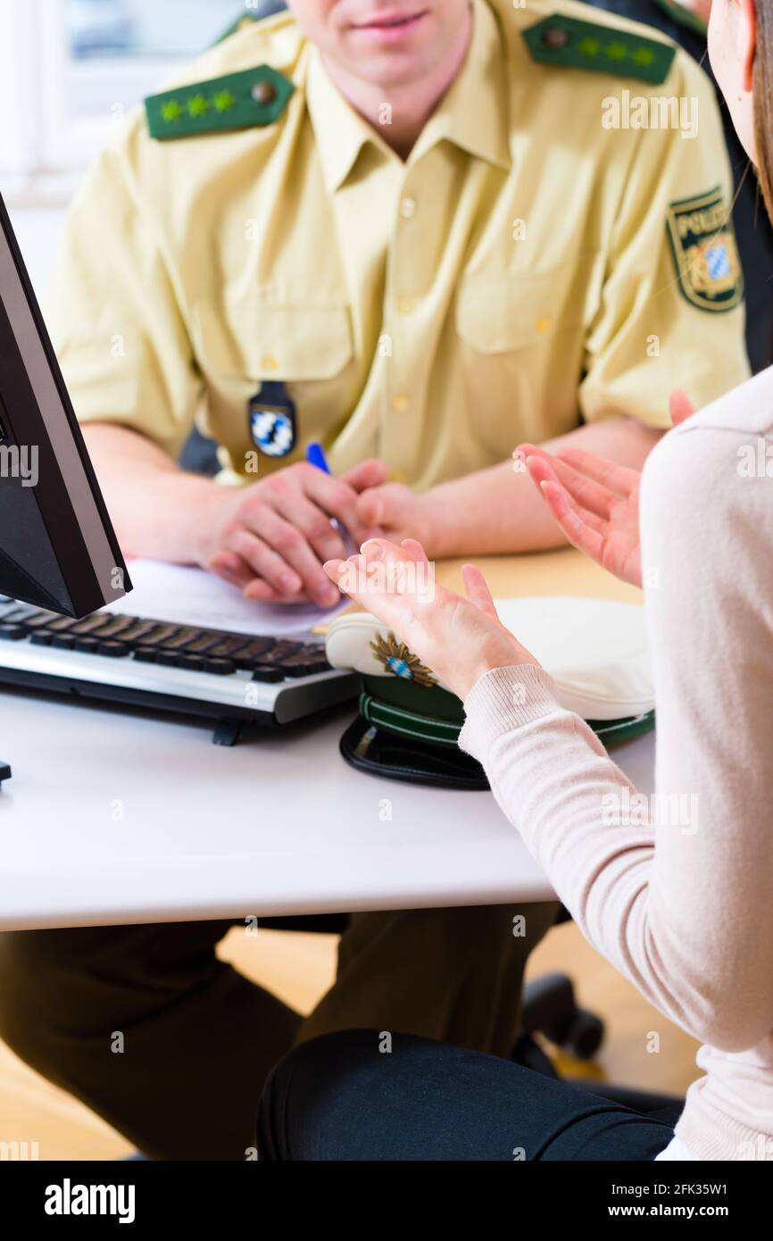 Police officer in police station working on the computer, registering a ...