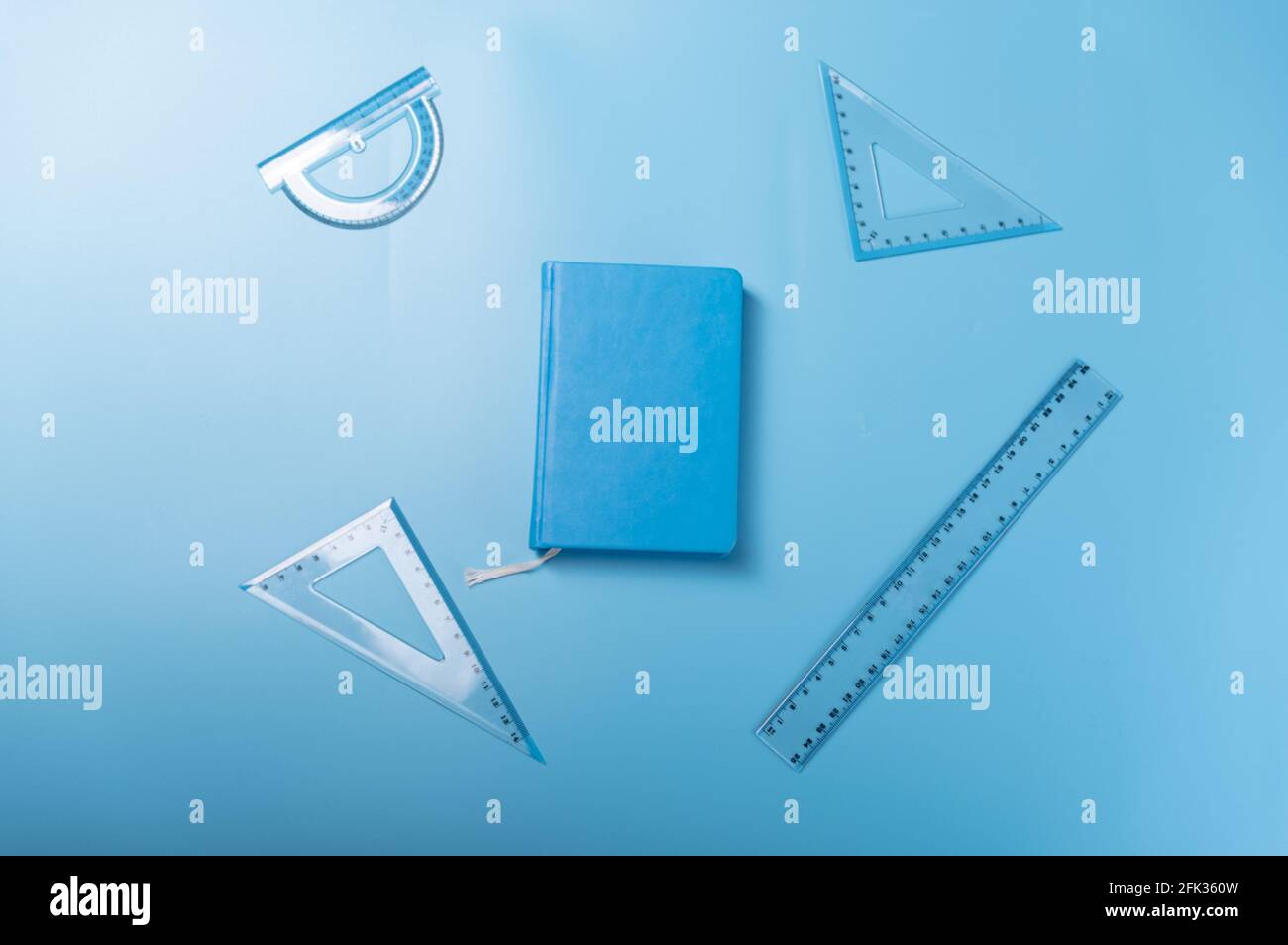 A variety of rulers and a notebook. Blue rulers and blue notepad on a ...