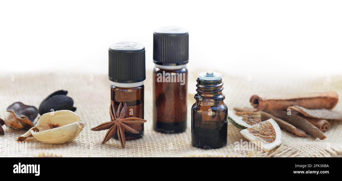 bottles of essential oil and cinnamon and anise on natural textile on ...