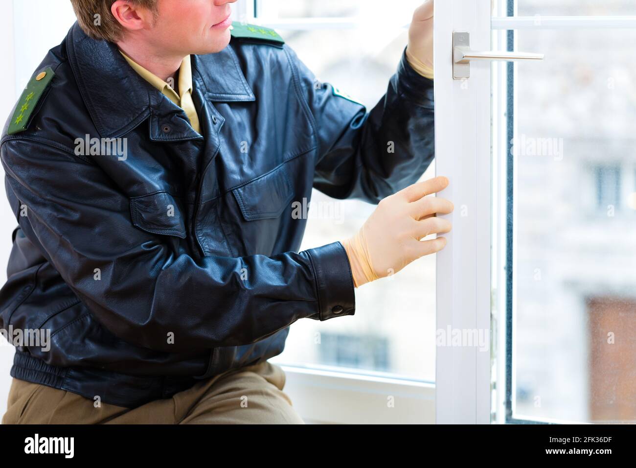 Police officer takes evidence on window after burglary Stock Photo - Alamy