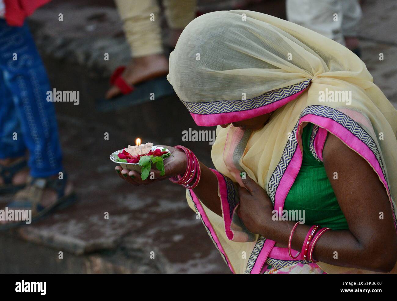 An Indian woman praying by the Ganges river in Varanasi Stock Photo - Alamy