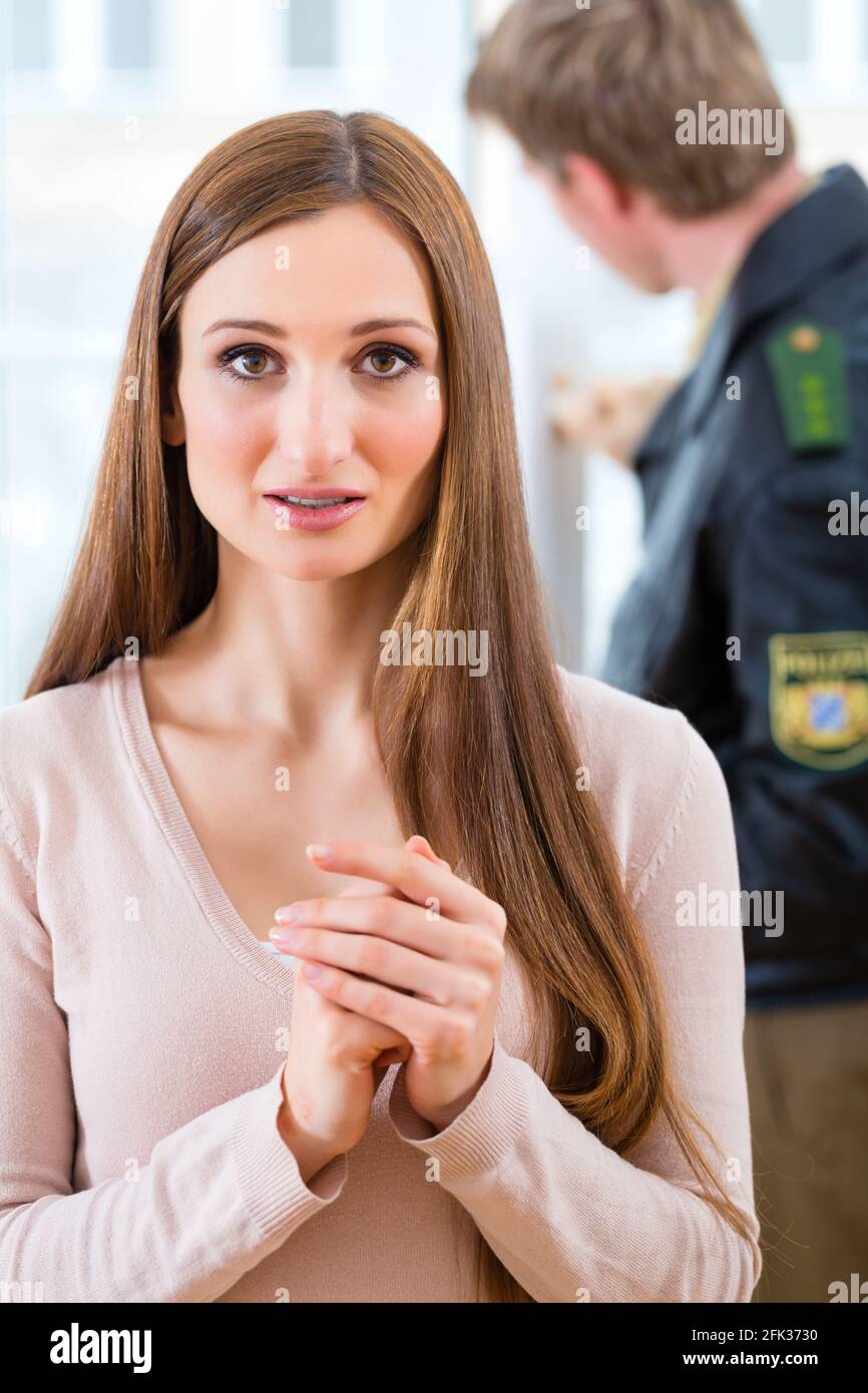 Police officer takes evidence on window after burglary in apartment ...