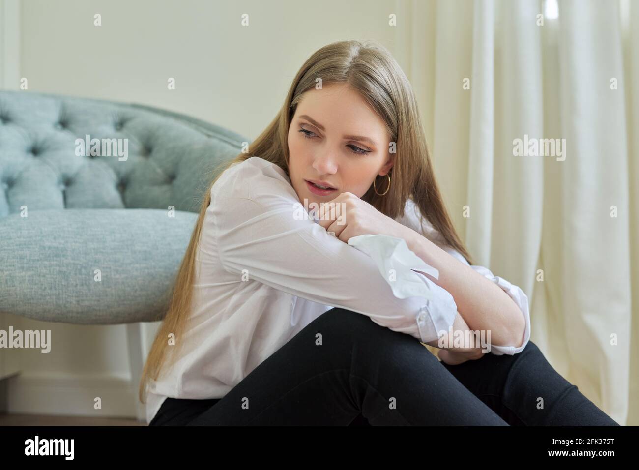 Upset crying young woman sitting at home on the floor Stock Photo - Alamy