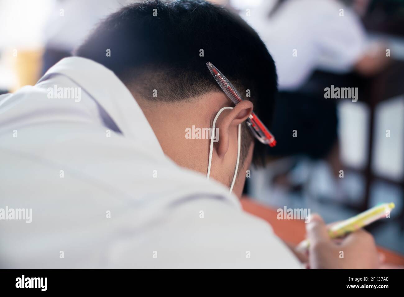 Students doing exam in classroom with stress Stock Photo - Alamy