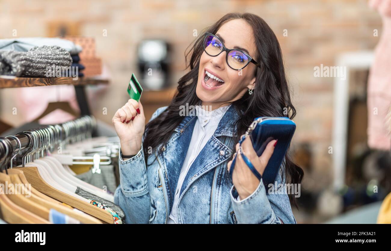 Careless shopaholic fmeale customer holds purse and credit card with ...