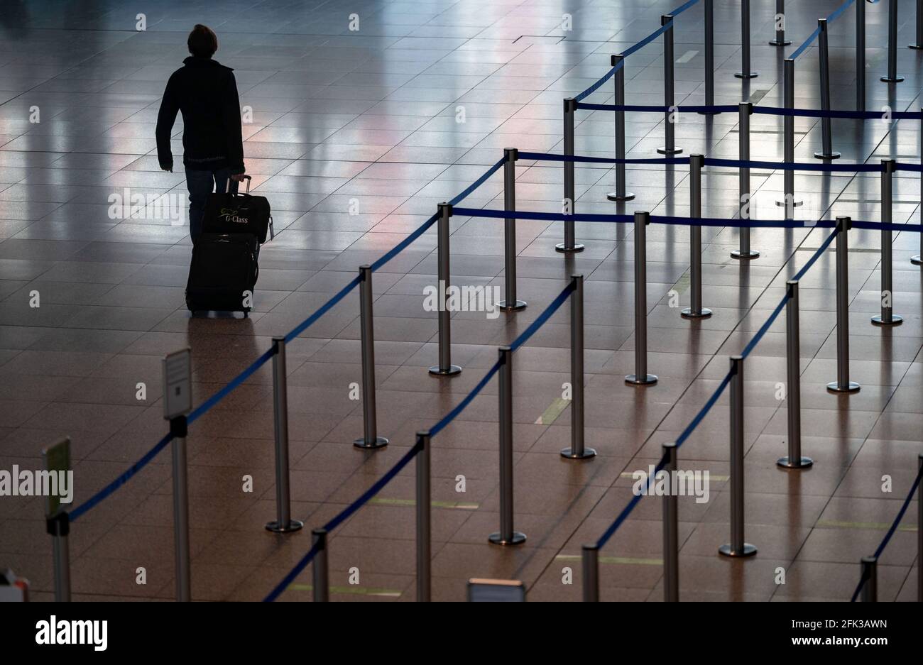 Stuttgart, Germany. 28th Apr, 2021. A passenger walks with his luggage ...