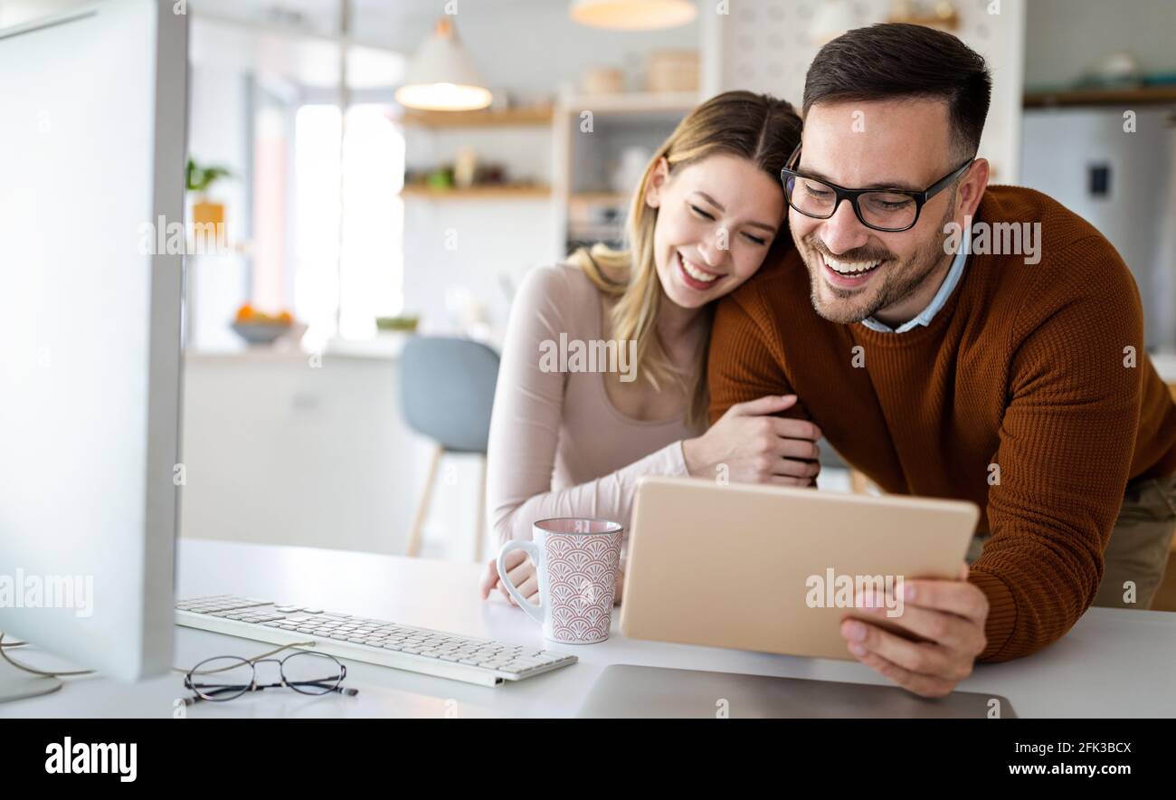 Positive couple having fun while working together remotely at home ...