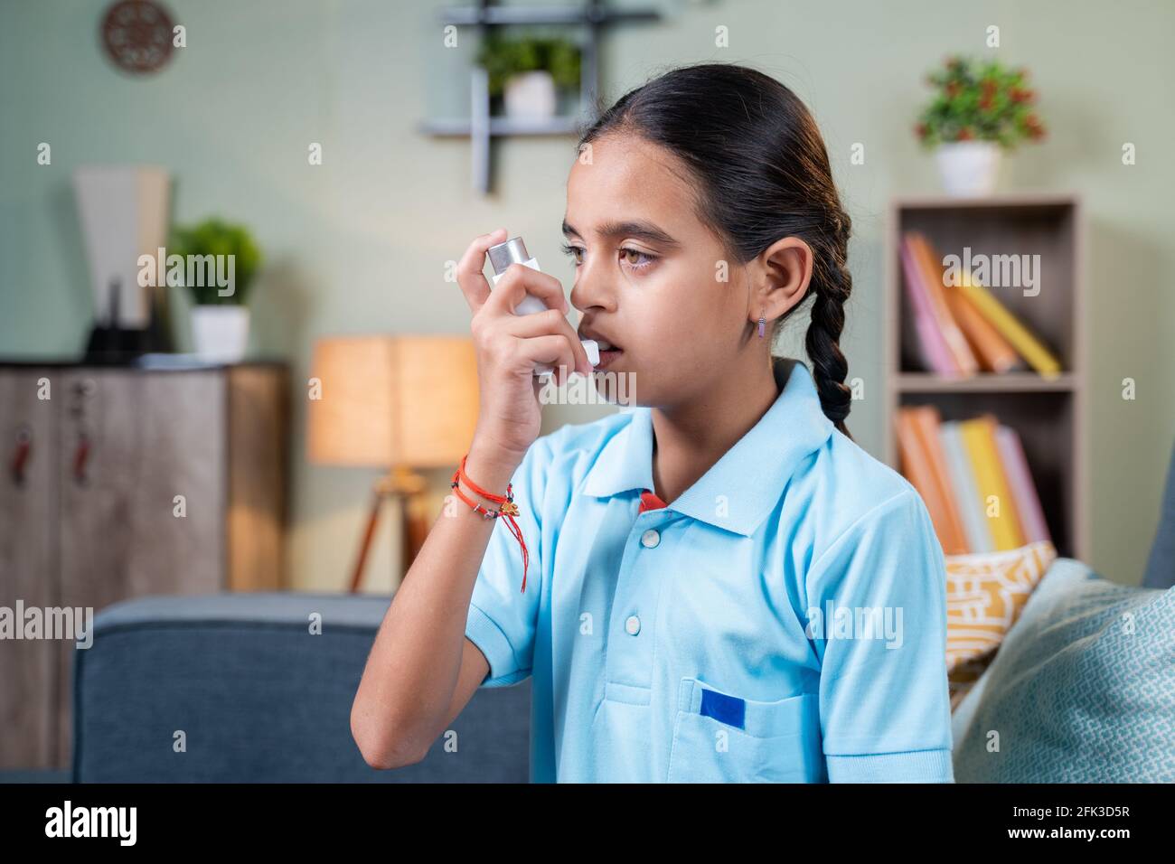 Side view young girl kid using asthma medication inhaler after taking ...
