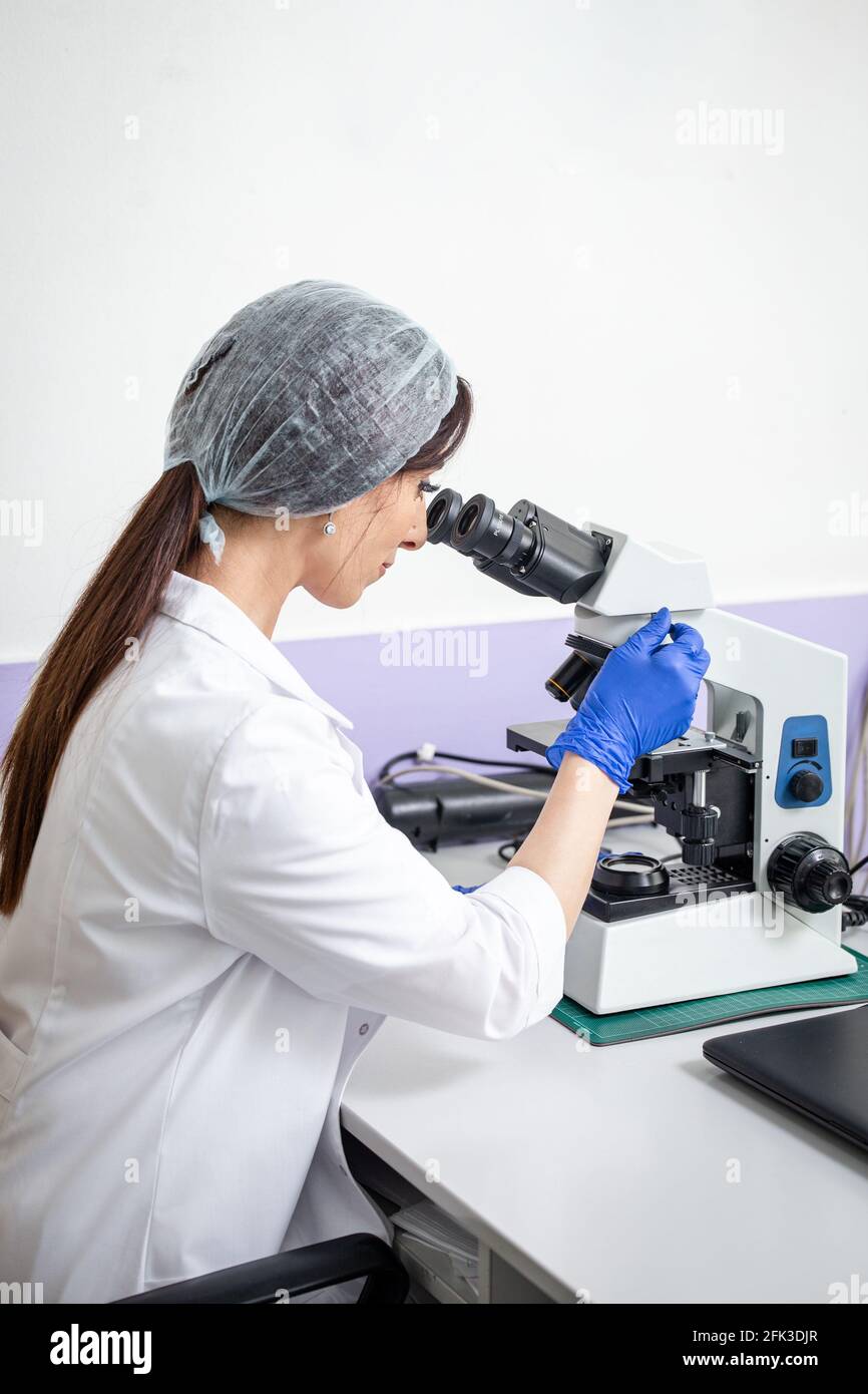 Girl lab technician works on a microscope Stock Photo - Alamy
