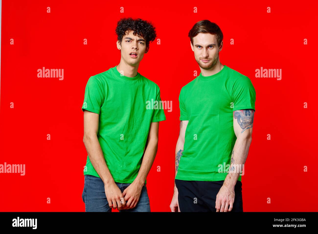 two friends in green t-shirts fun communication red background Stock ...