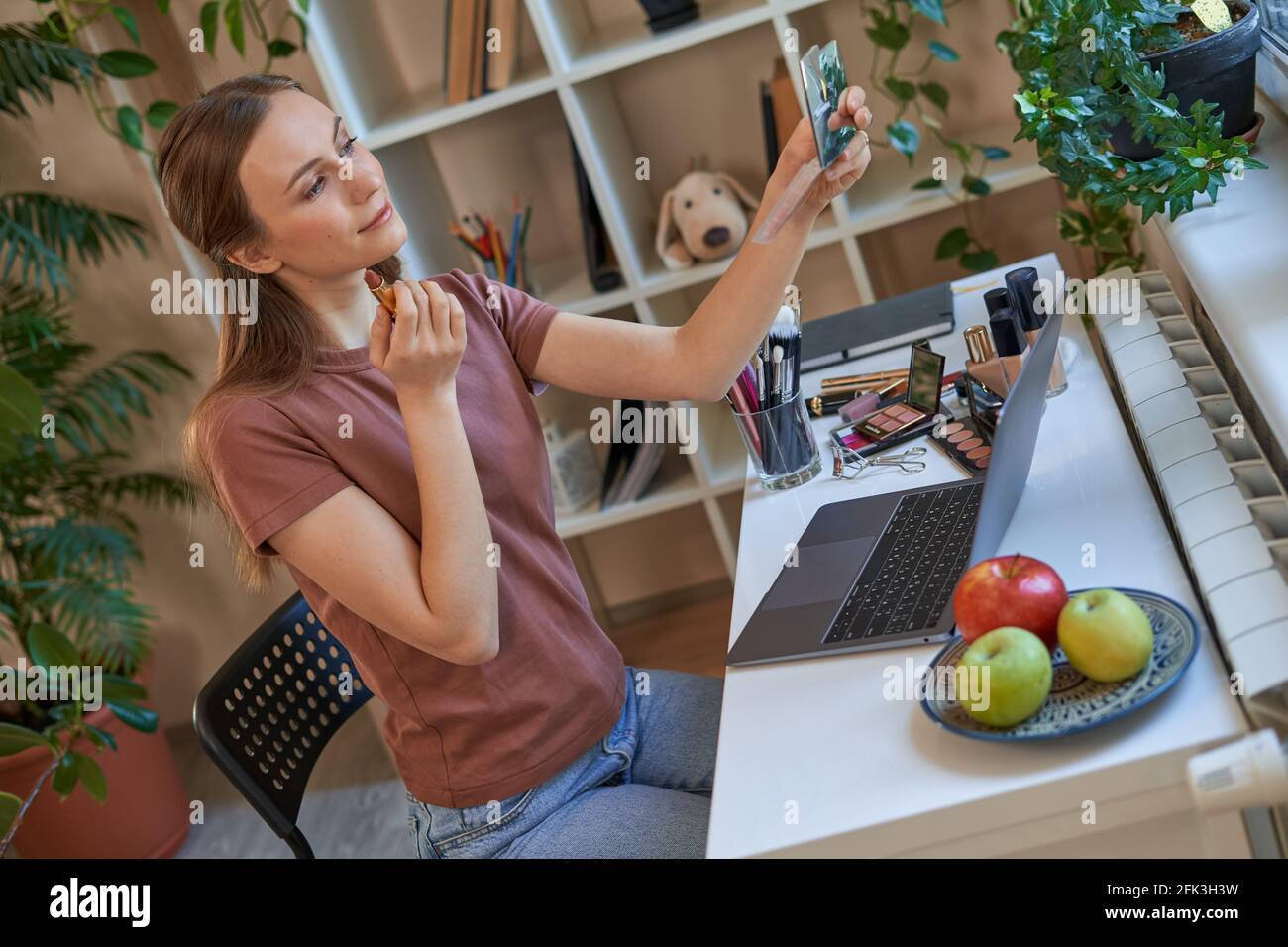 Beautiful lady applying lipstick during online makeup tutorials Stock ...