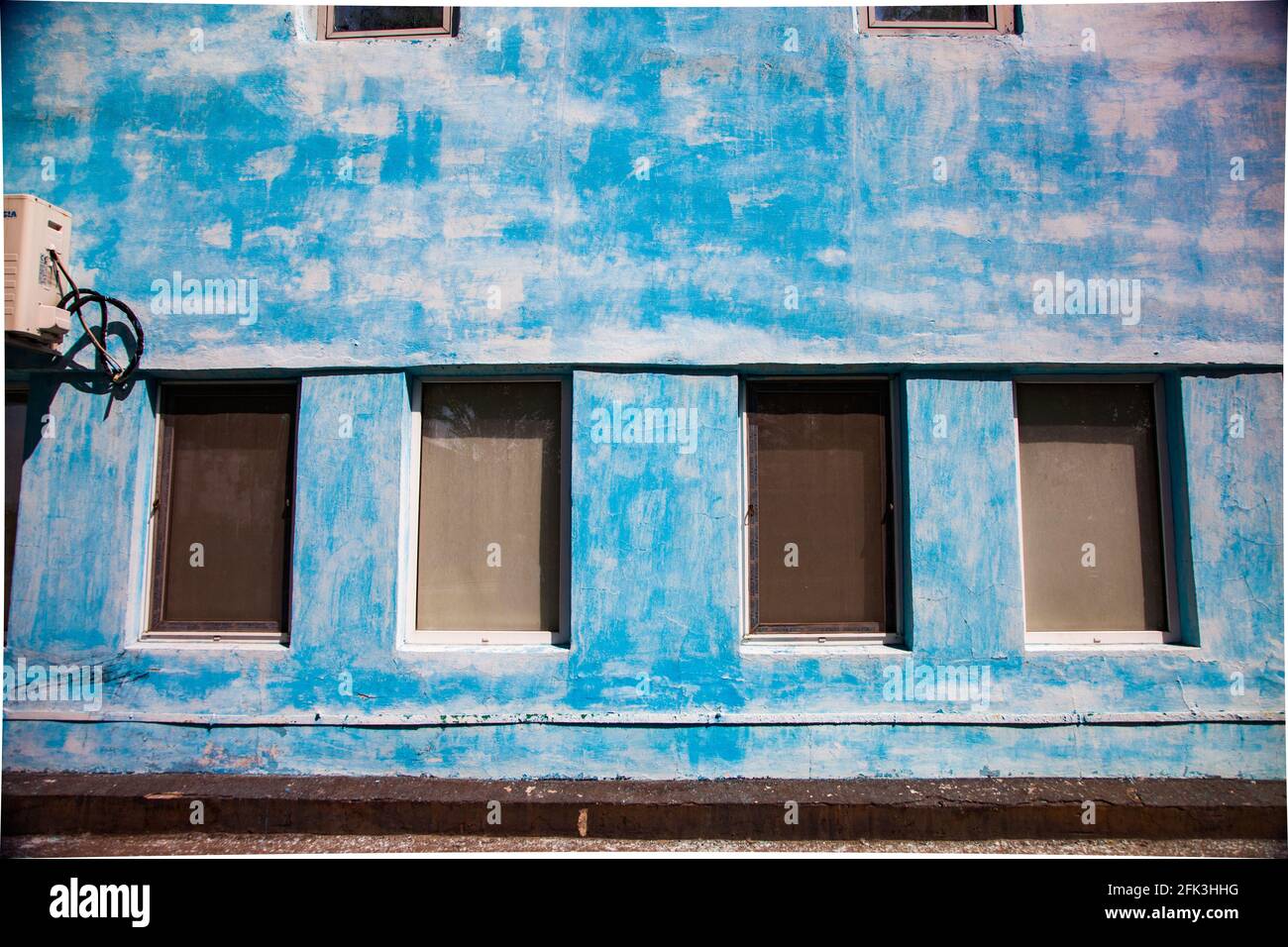 Vintage painted factory building wall with windows. Blue and white ...