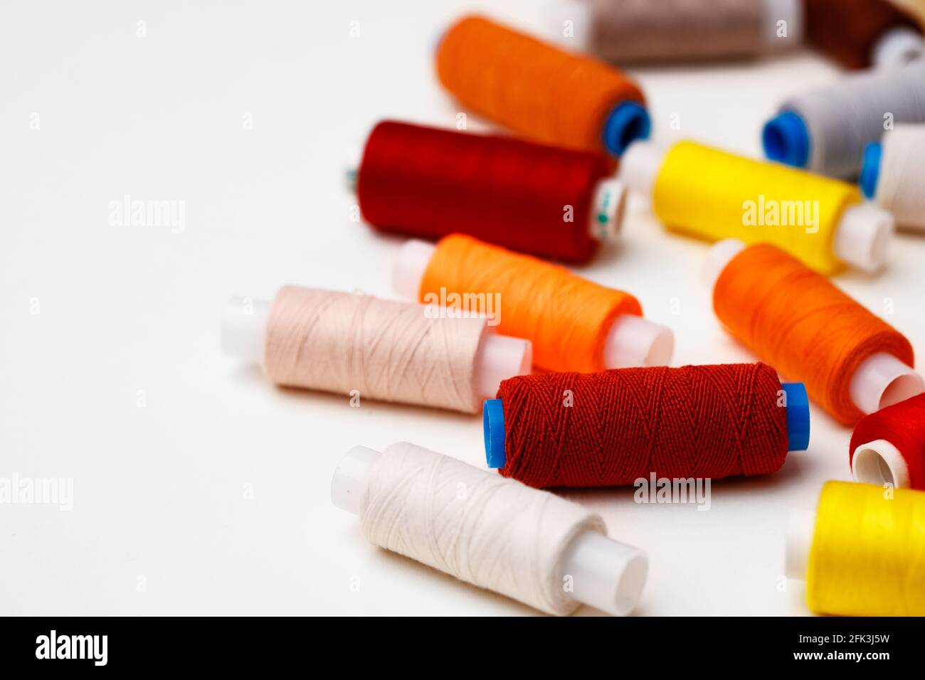Colored spools of threads on white background Stock Photo - Alamy