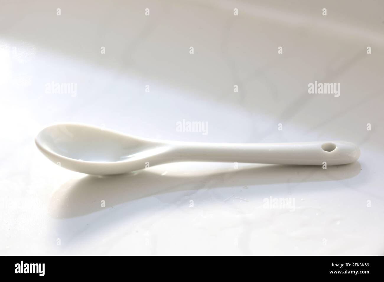 Close-up of a White Ceramic Spoon and reflected shadow Stock Photo - Alamy