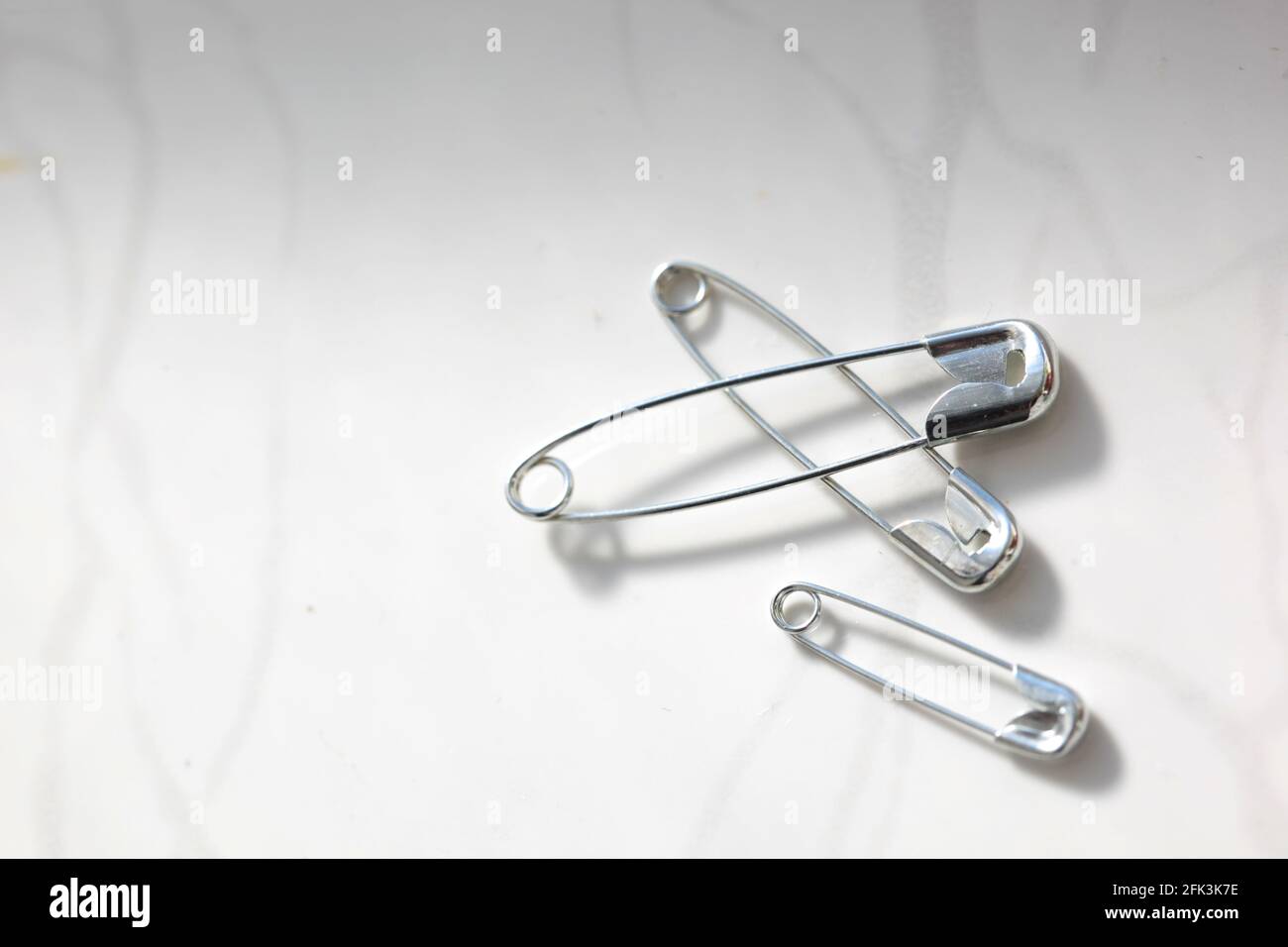 Close-up of three safety pins on a grey-white background Stock Photo ...