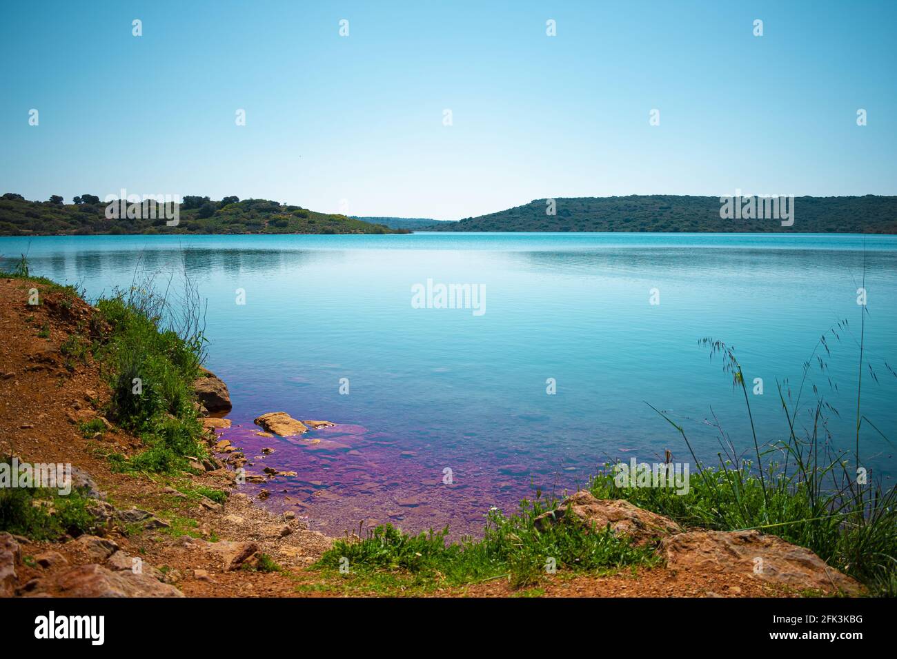 Gorgeous blue lake with sunlight glinting in it, surrounded by hills ...