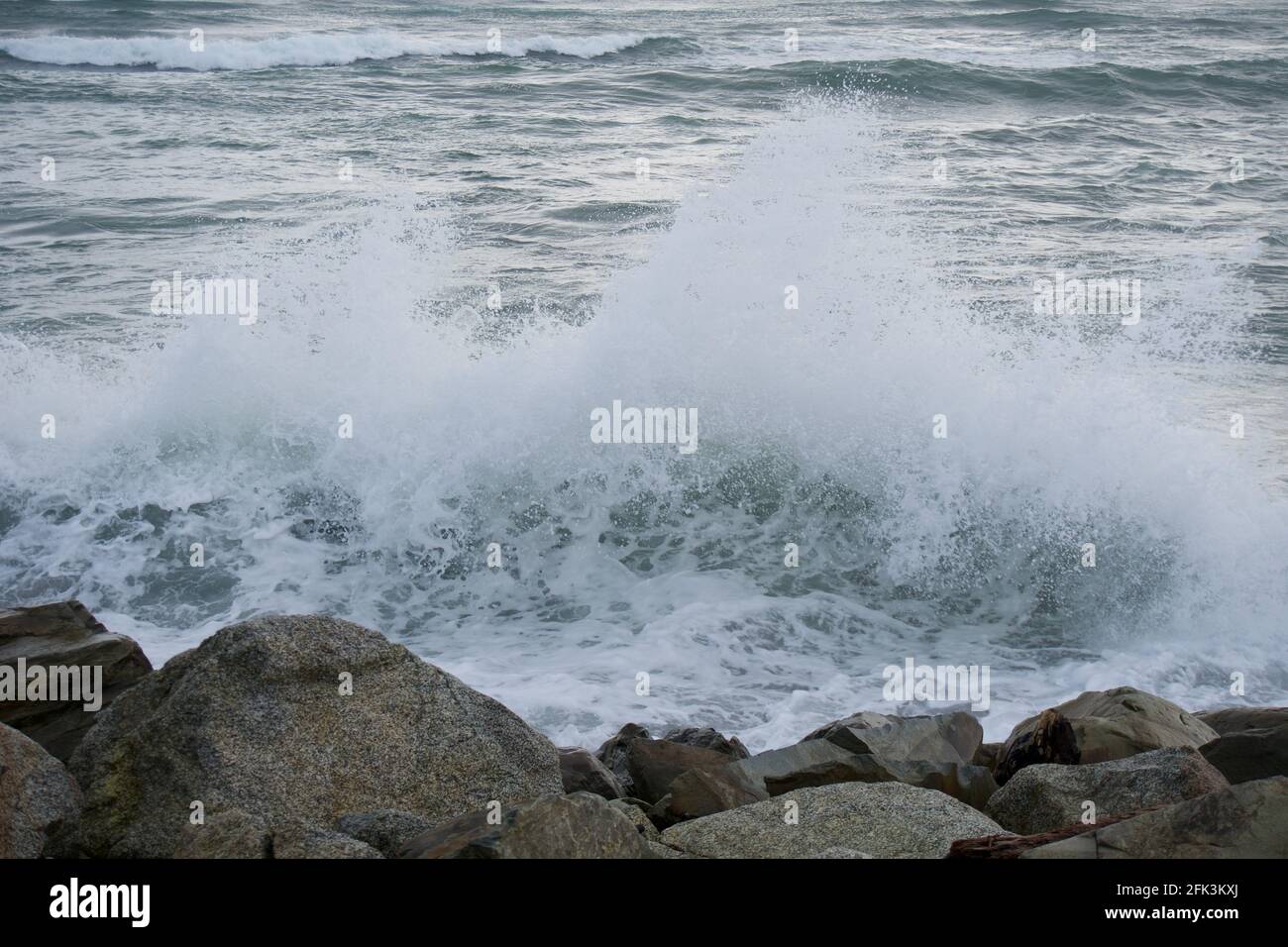 Shore at a beach with sharp rocks and angry waves coming towards them ...