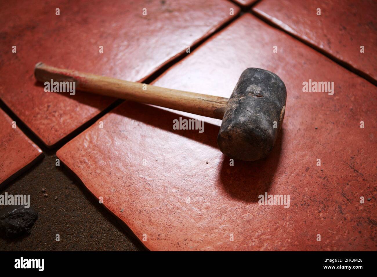 Wooden hammer laying on freshly laid ceramics tile Stock Photo - Alamy