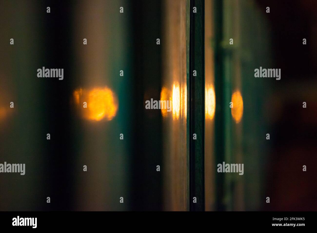 Abstract view of reflections of shiny metal pipes in back light. Warm ...