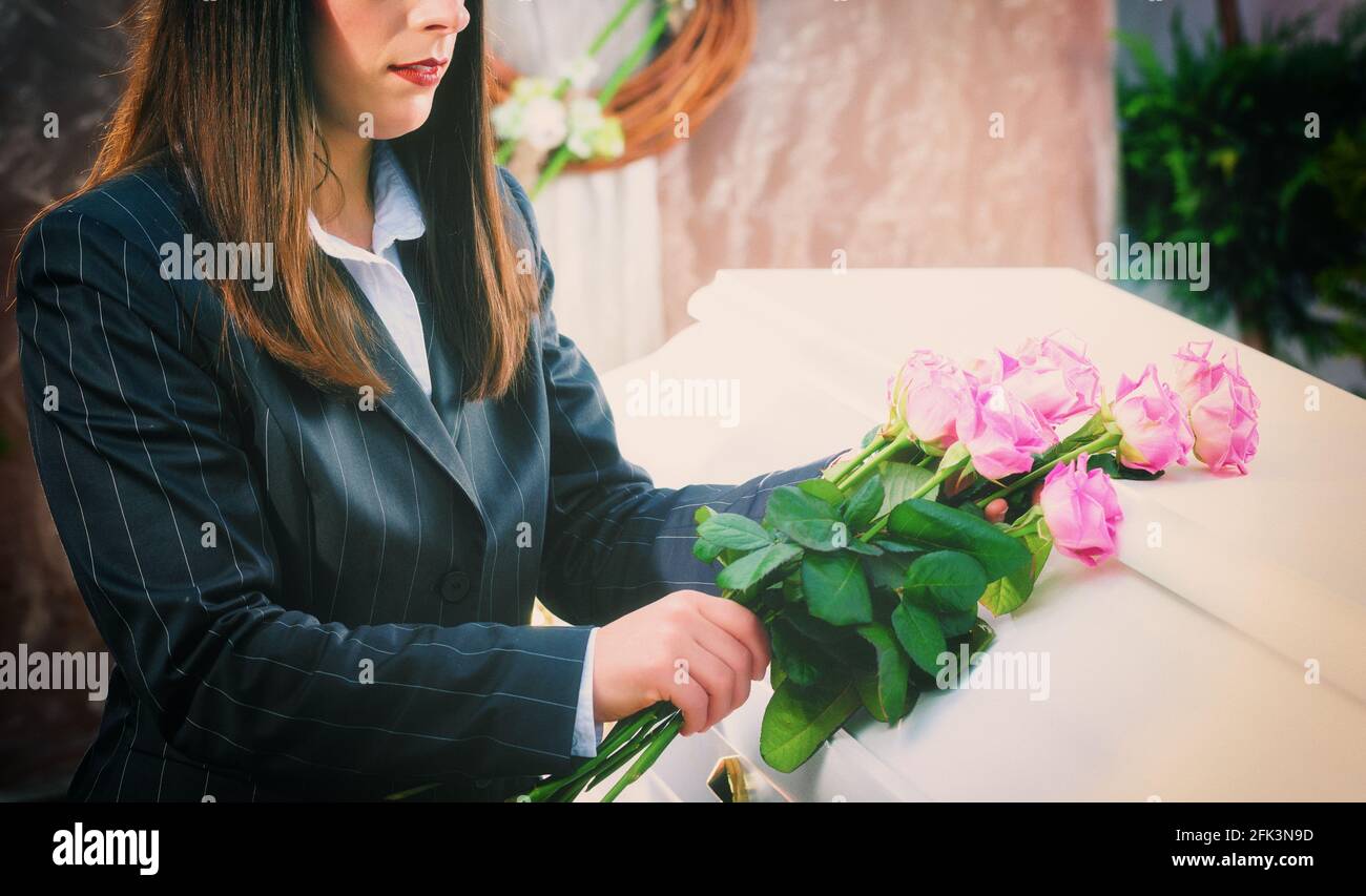 Woman putting rose on coffin at funeral Stock Photo - Alamy