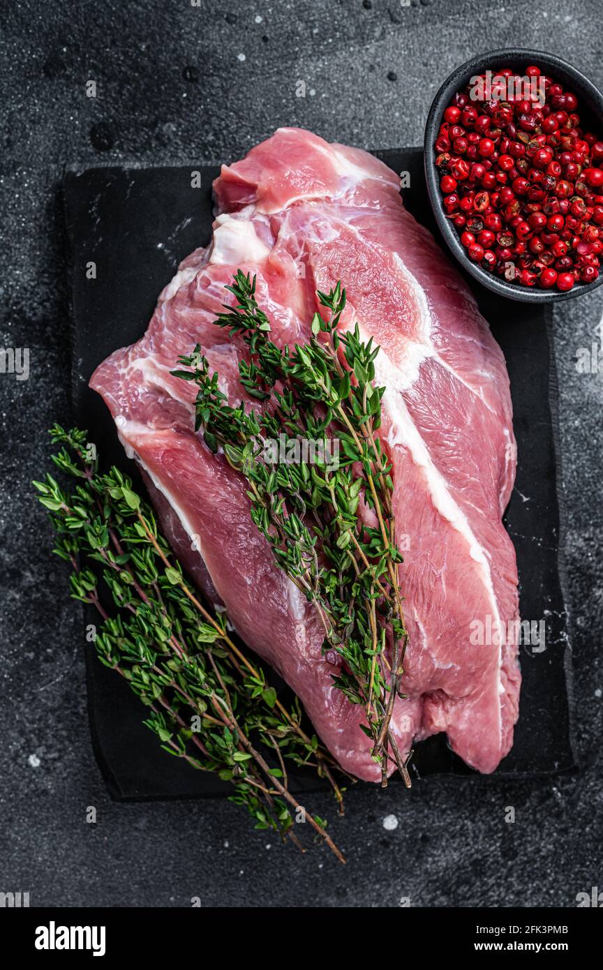 Raw pork shoulder meat cut on a marble board. Black background. Top ...
