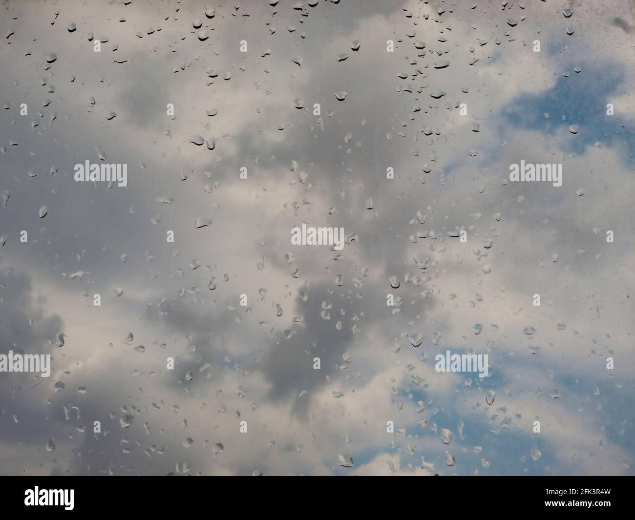 Sunny summer skies on a day with lots of clouds, seen from behind rain ...