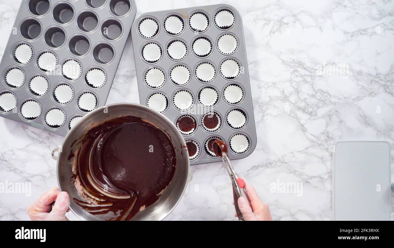 Flat lay. Step by step. Scooping cupcake batter into mini cupcake lines ...