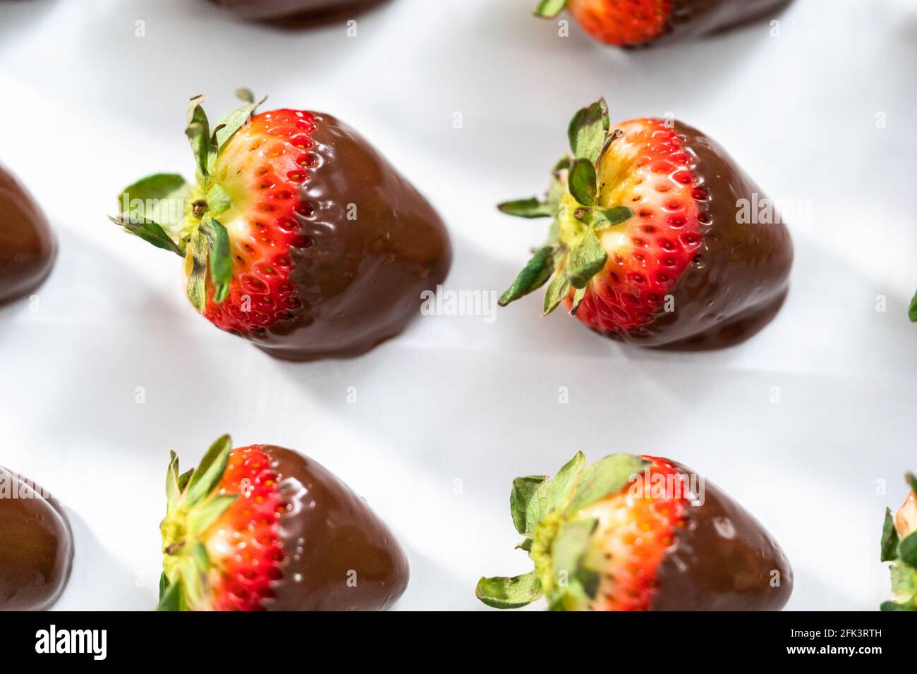 Making white and dark chocolate dipped strawberries Stock Photo - Alamy