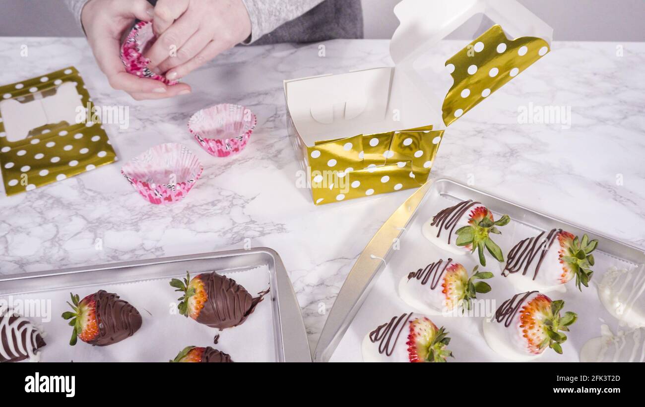 Step by step. Packaging chocolate dipped strawberries into a paper box ...