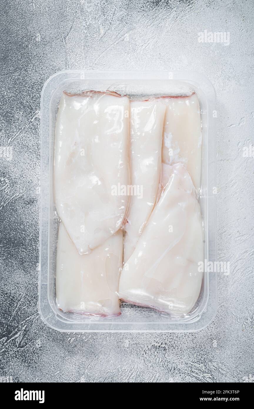 Fresh Raw Squid or Calamari in a vacuum package on a kitchen table ...