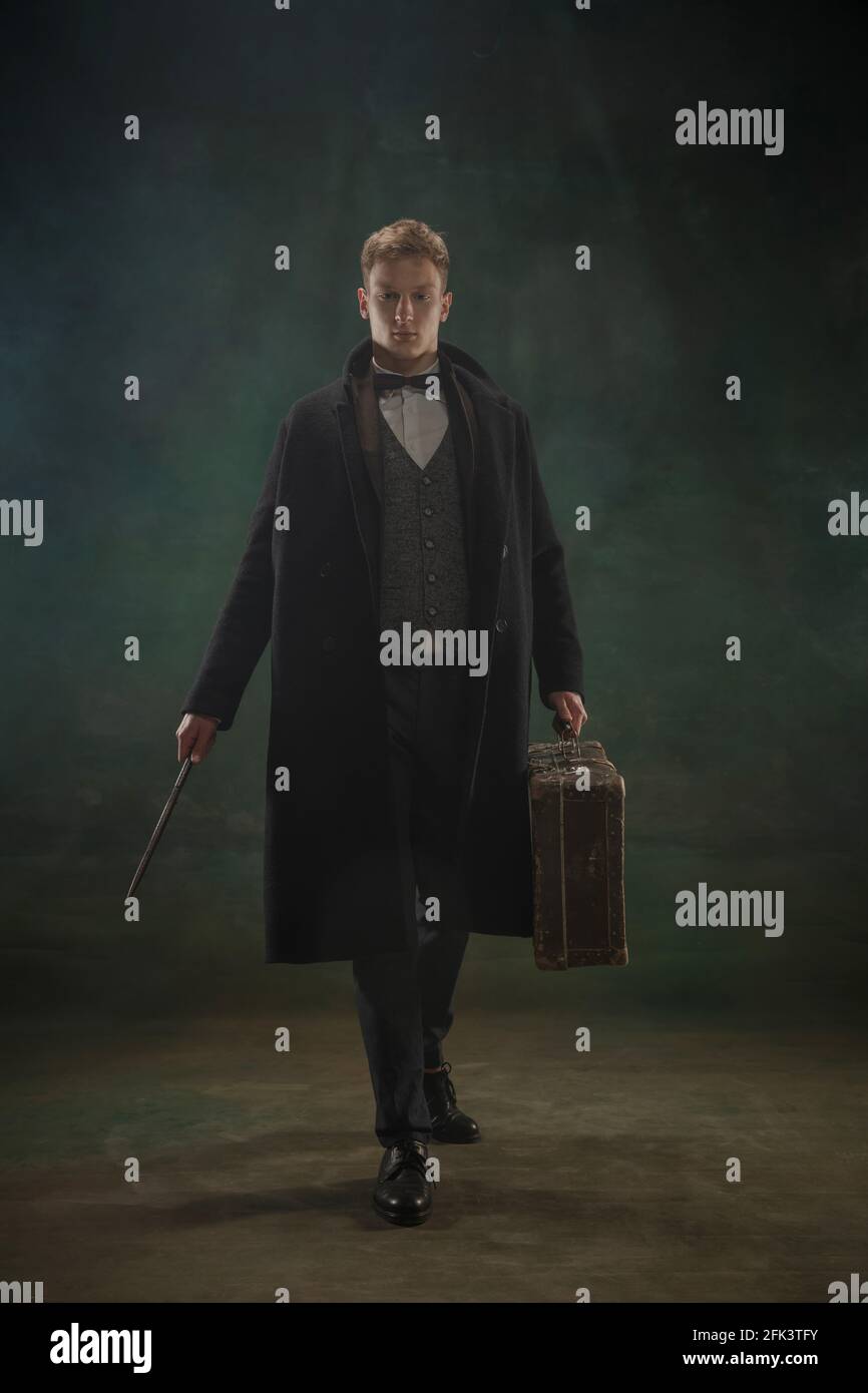 Young man in art action isolated on dark green background. Retro style ...