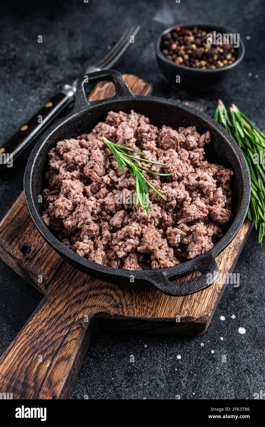 Fried mince beef meat in a pan for cooking pasta. Black background. Top ...