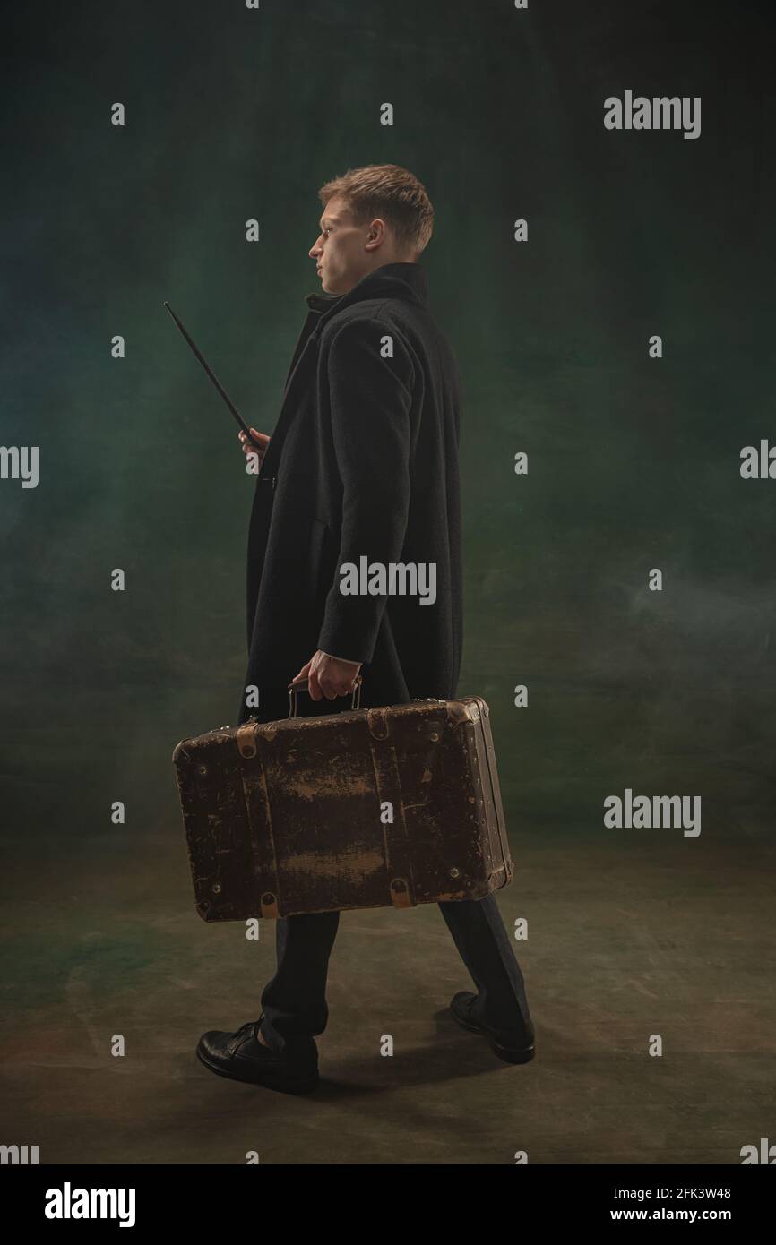 Young man in art action isolated on dark green background. Retro style ...