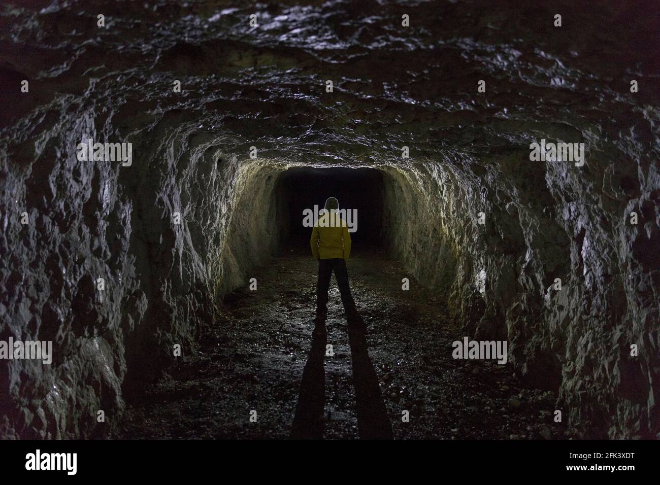 Rear view of a boy in a cave, cavern from ww1, illuminated from the ...