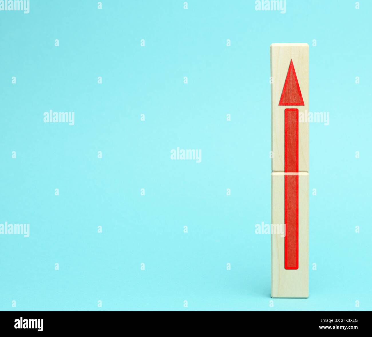wooden block with an upward arrow on a bluee background, the process of ...