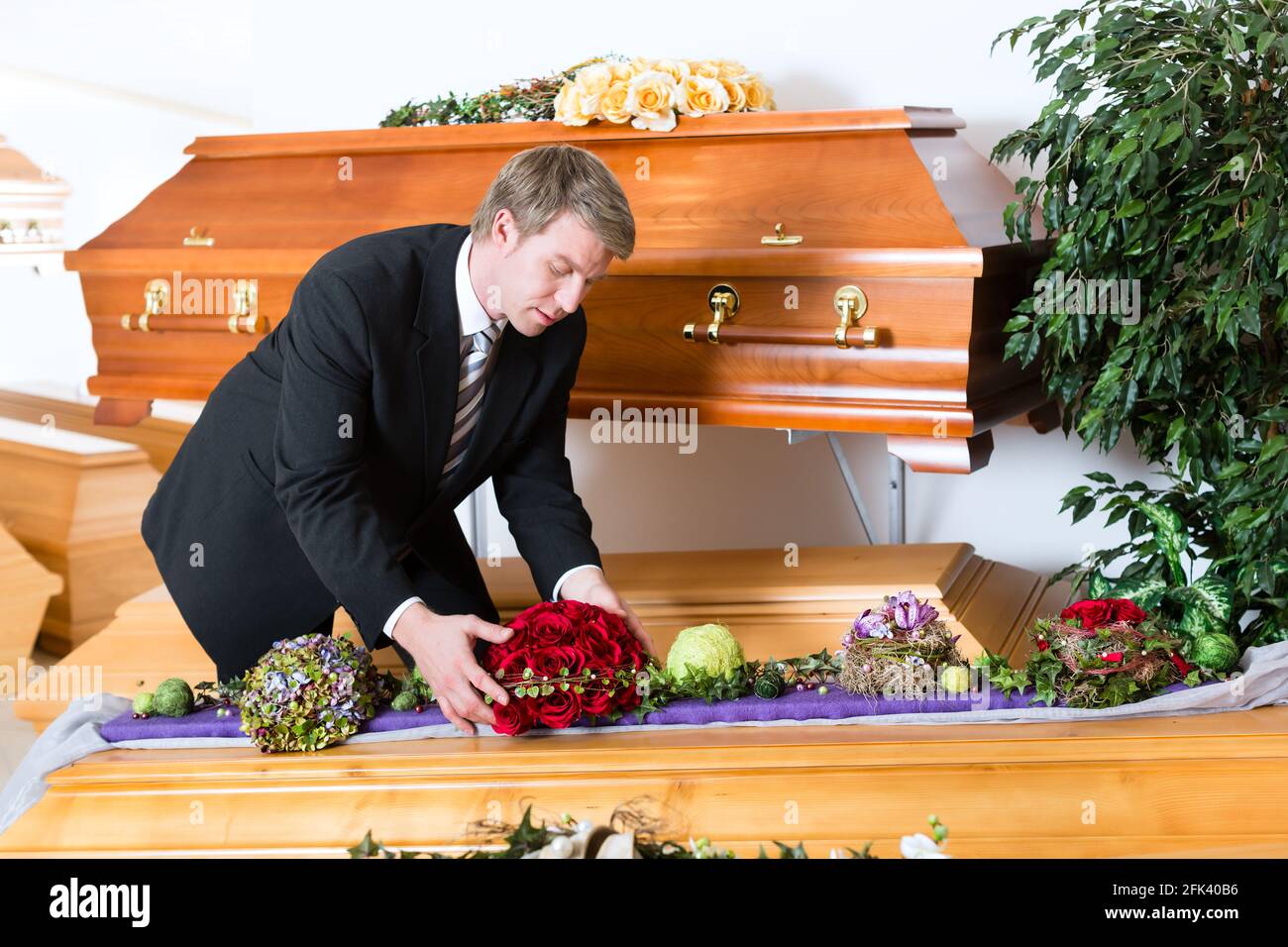 Undertaker in his store with a display of coffins Stock Photo - Alamy