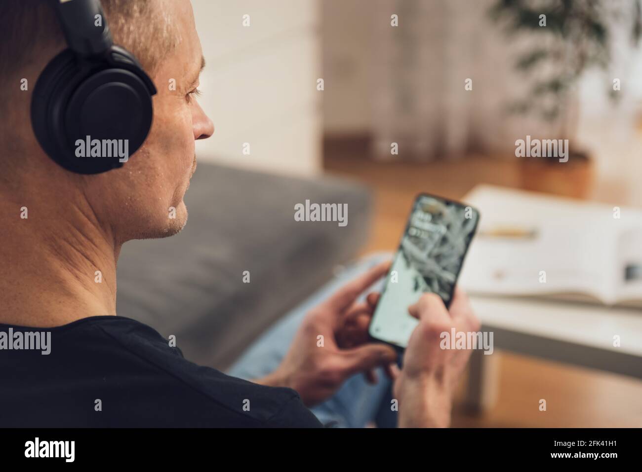 The man in headphones and with a smartphone. Back view Stock Photo - Alamy