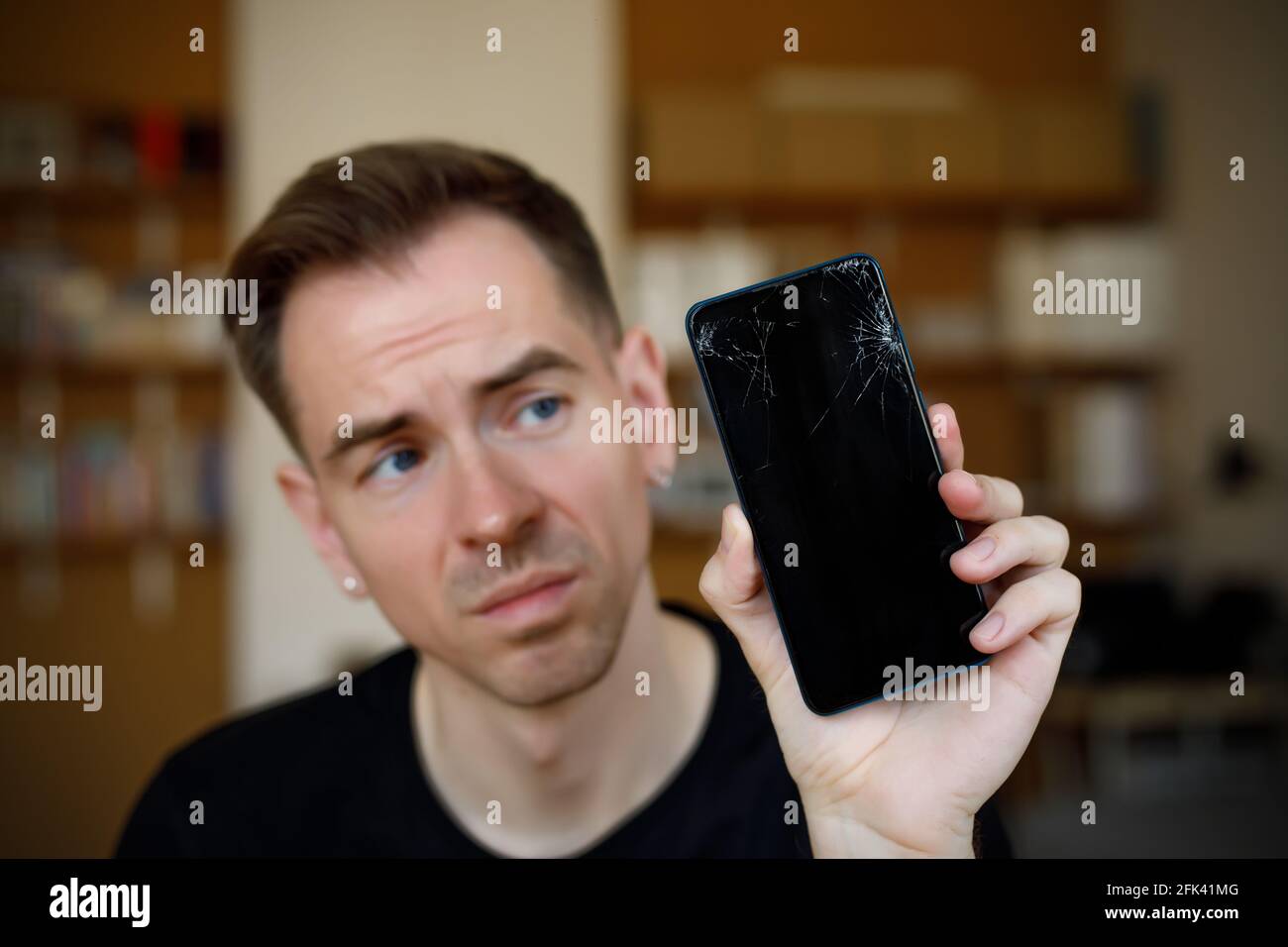 The sad man holds a broken smartphone with cracks Stock Photo - Alamy
