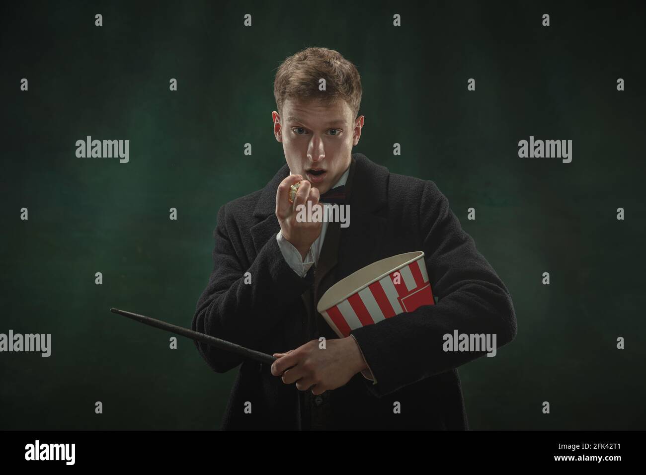 Young man in art action isolated on dark green background. Retro style ...