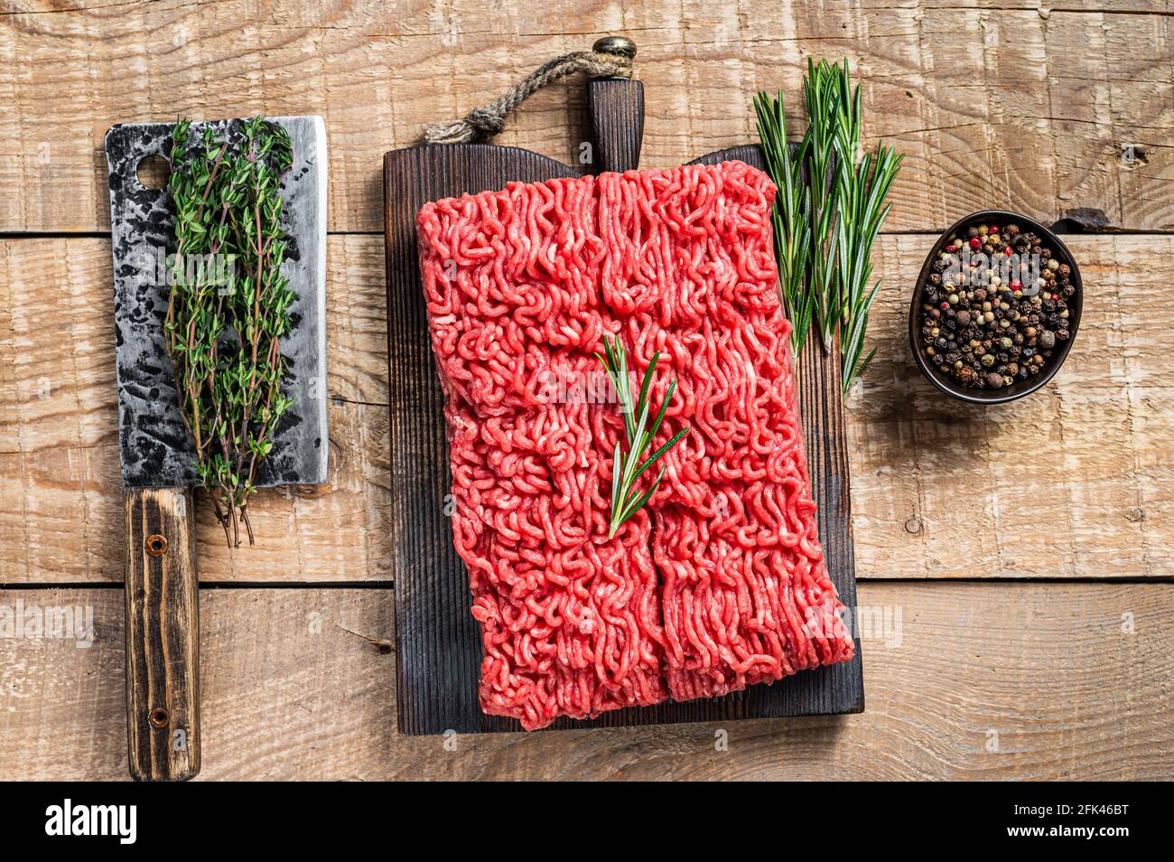 Fresh Raw mince beef meat on a butcher cutting board with cleaver ...