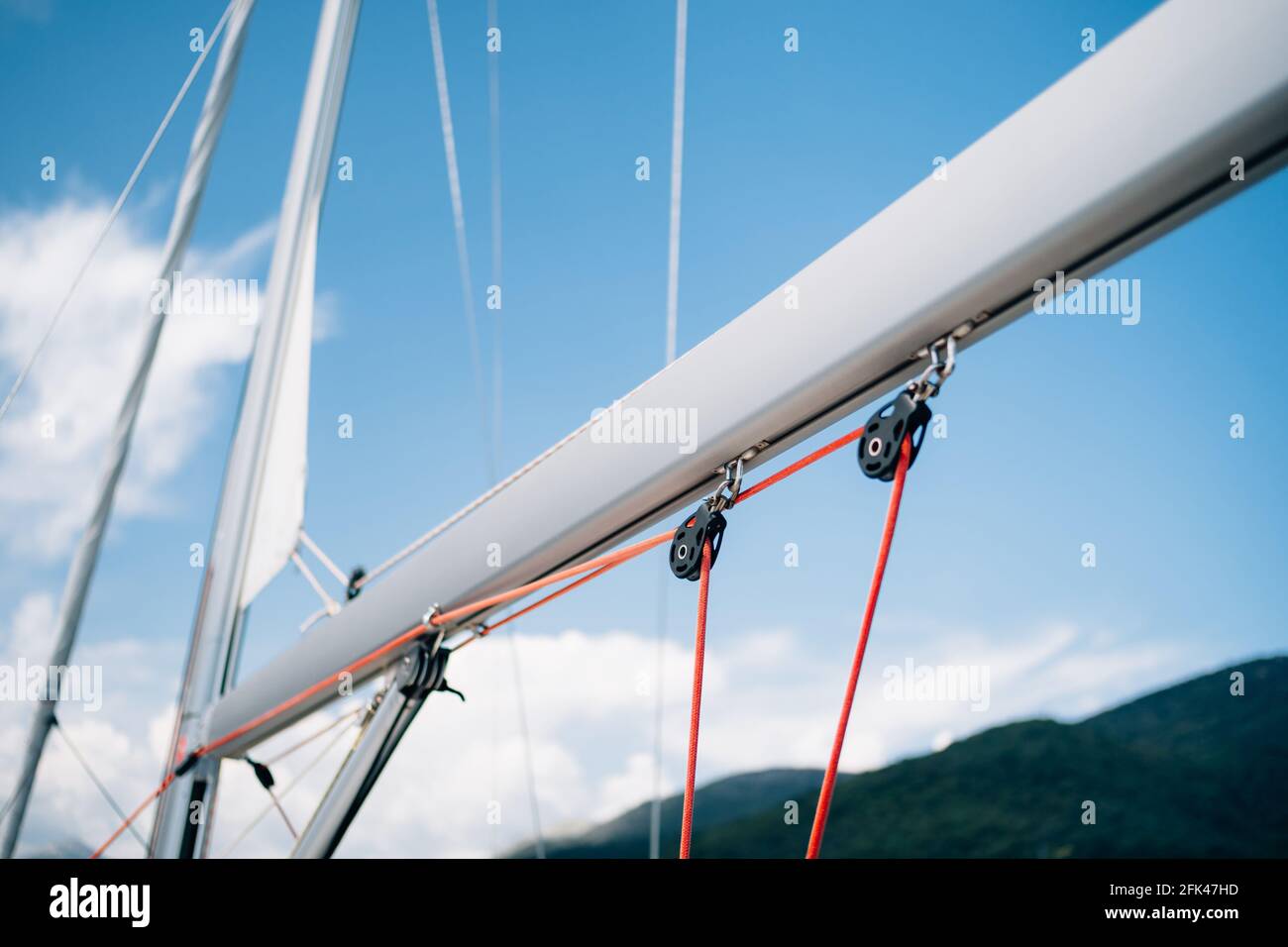 Winches with red ropes on a white mast of a sailing yacht against a ...