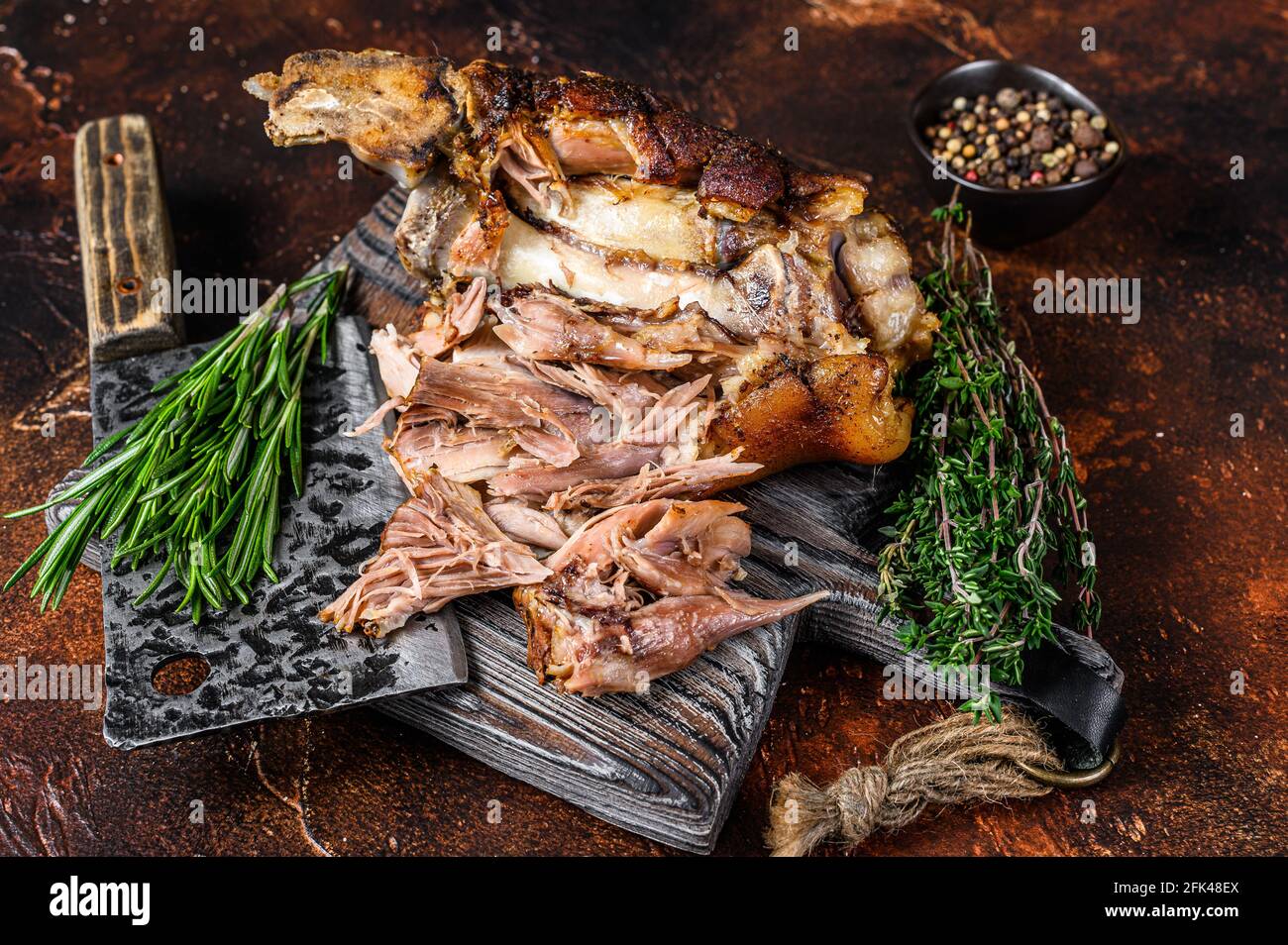 Roasted and cut German pork knuckle eisbein meat on a wooden board with ...