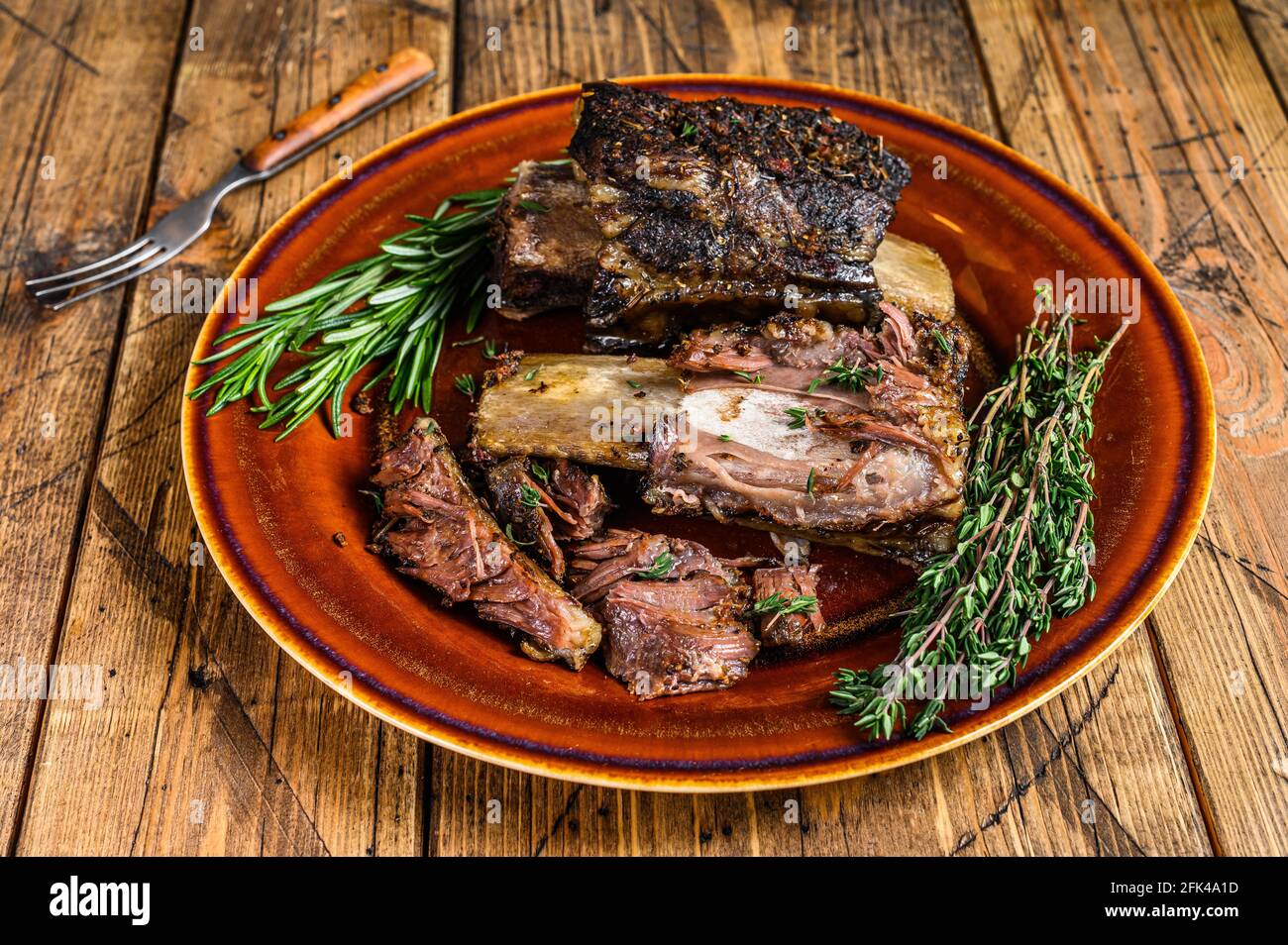 Grilled short beef ribs with thyme on a rustic plate. wooden background ...