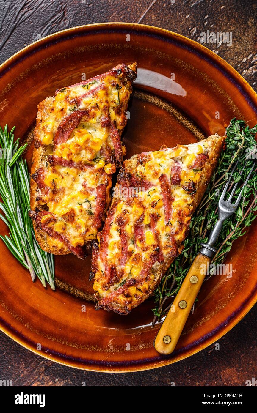 Hot baked sandwich on Baguette bread with ham, bacon, vegetables and ...